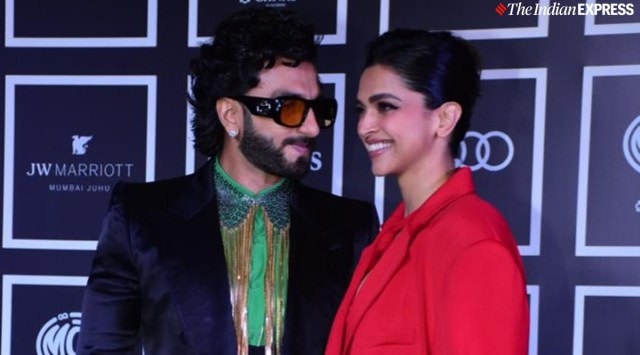 Deepika Padukone looks on as Ranveer Singh dances for photographers ...