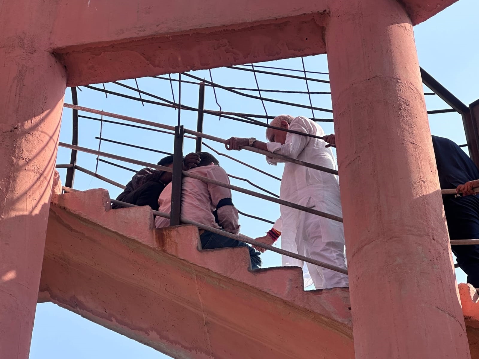 To convince 2 protesters to come down from overhead water tank ...