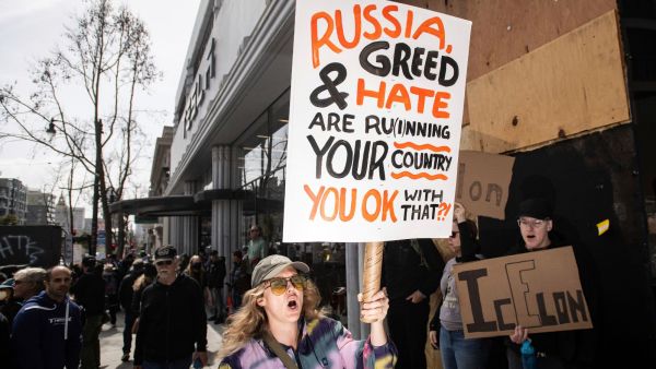 In pictures: Hundreds protest outside Tesla showrooms over Musk’s role ...