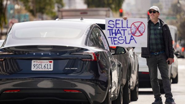 In pictures: Hundreds protest outside Tesla showrooms over Musk’s role ...
